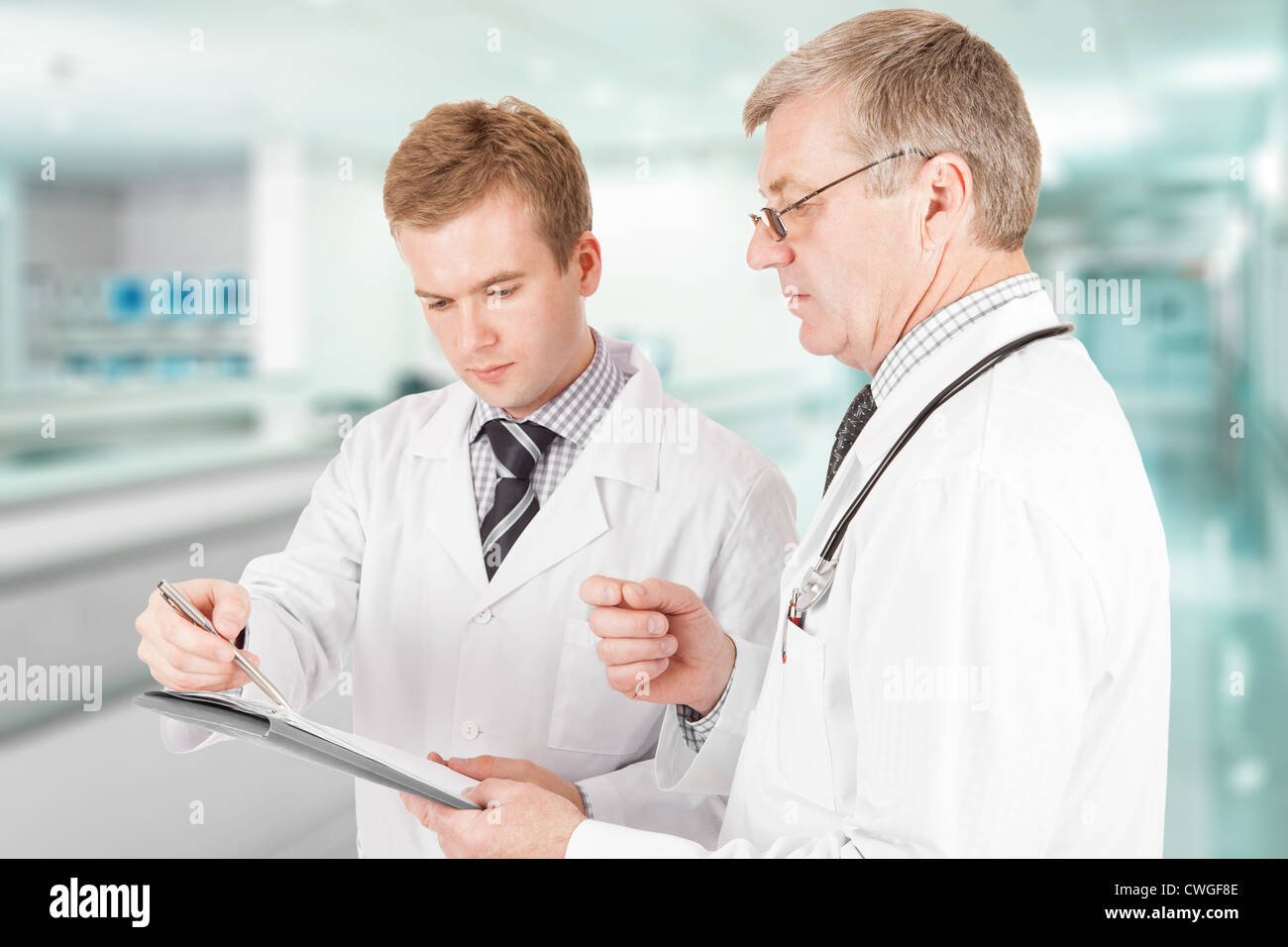Two medical doctors talking about something next to registration desk ...