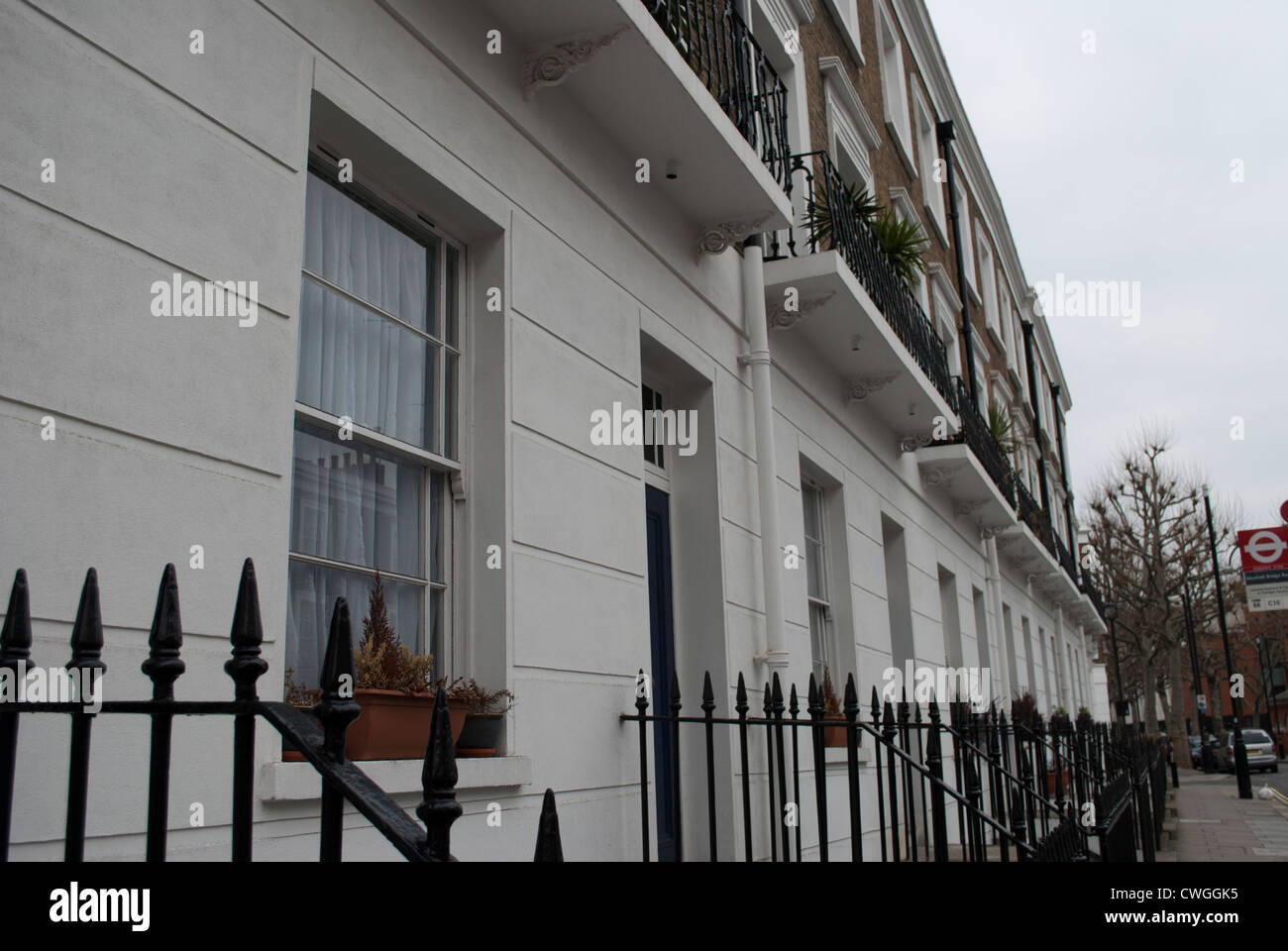 Row of white painted terrace buildings with black iron railings on John ...