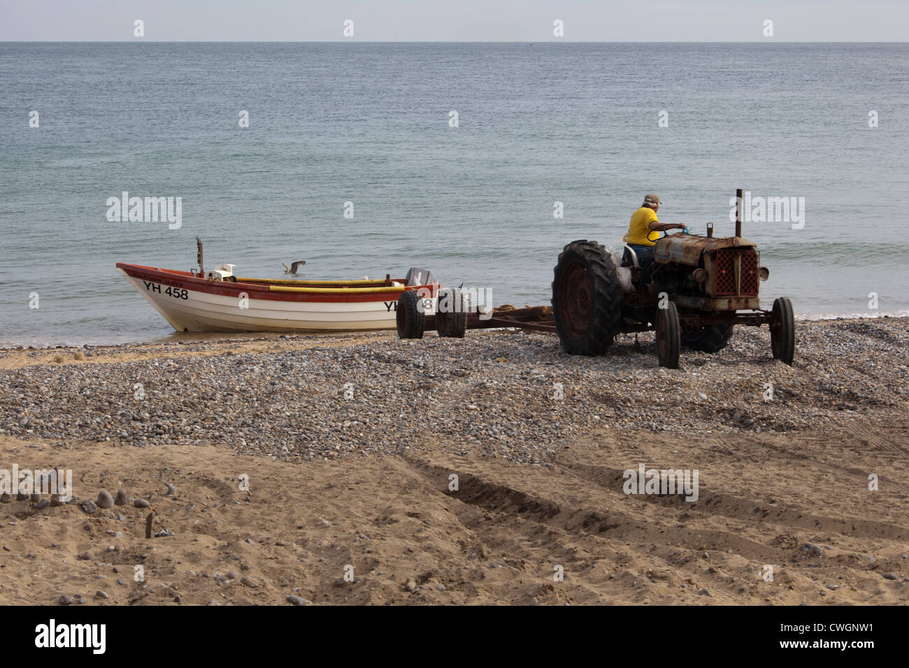 Norfolk tractor pulling boat on beach Stock Photo - Alamy