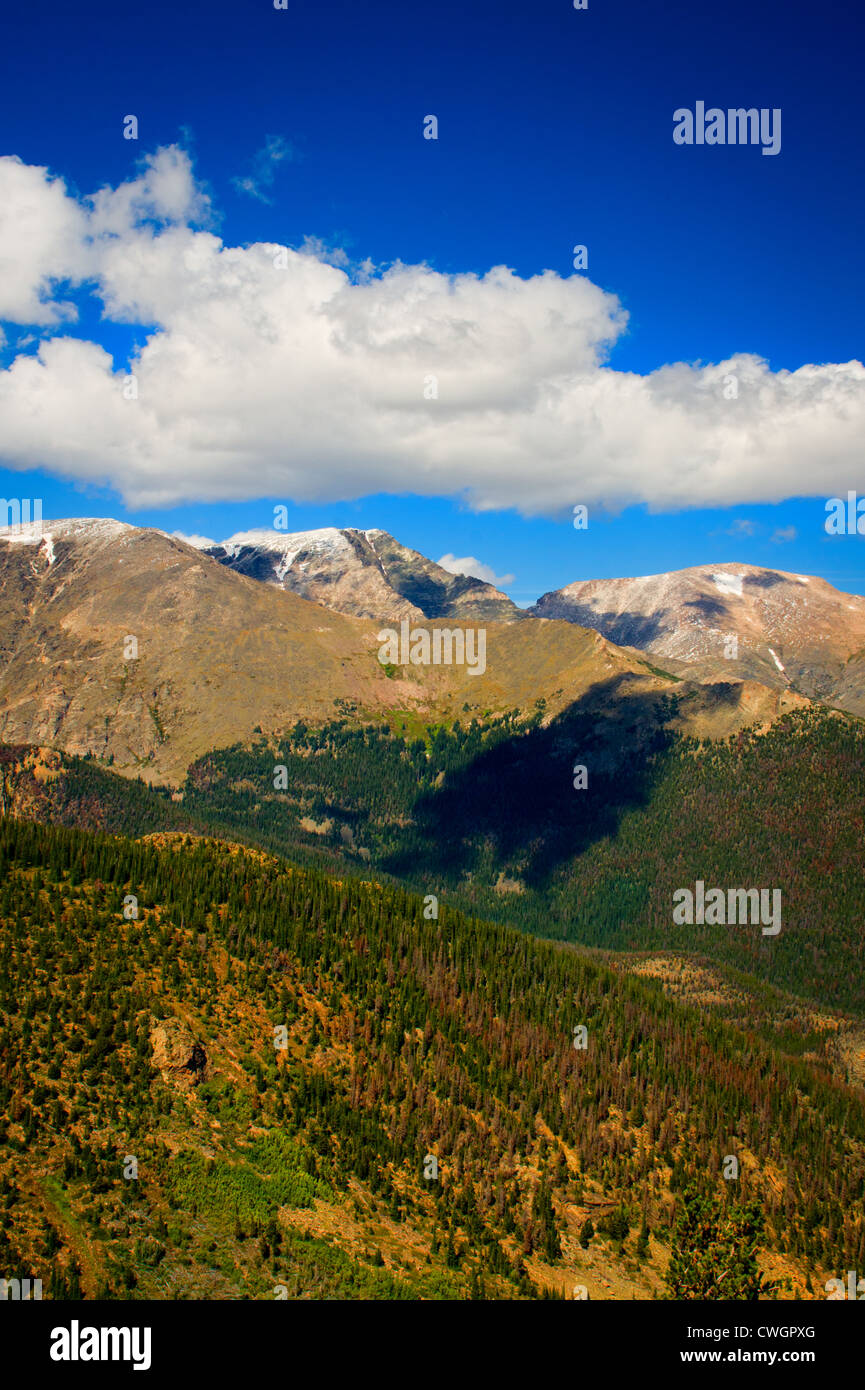 Clouds float on the brilliant blue sky over the Colorado Rockies along ...