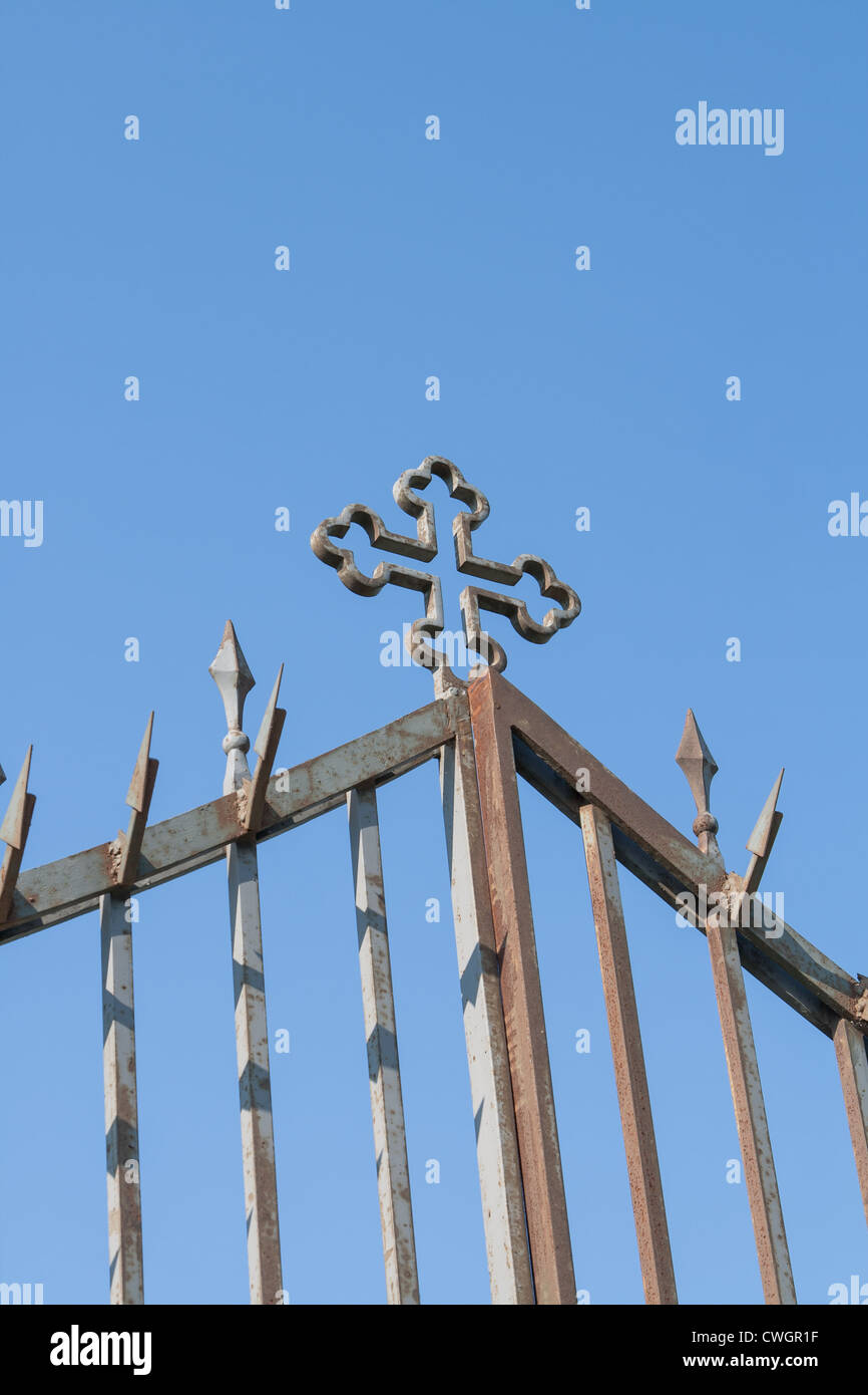 gate with cross from metal on blue air background Stock Photo - Alamy