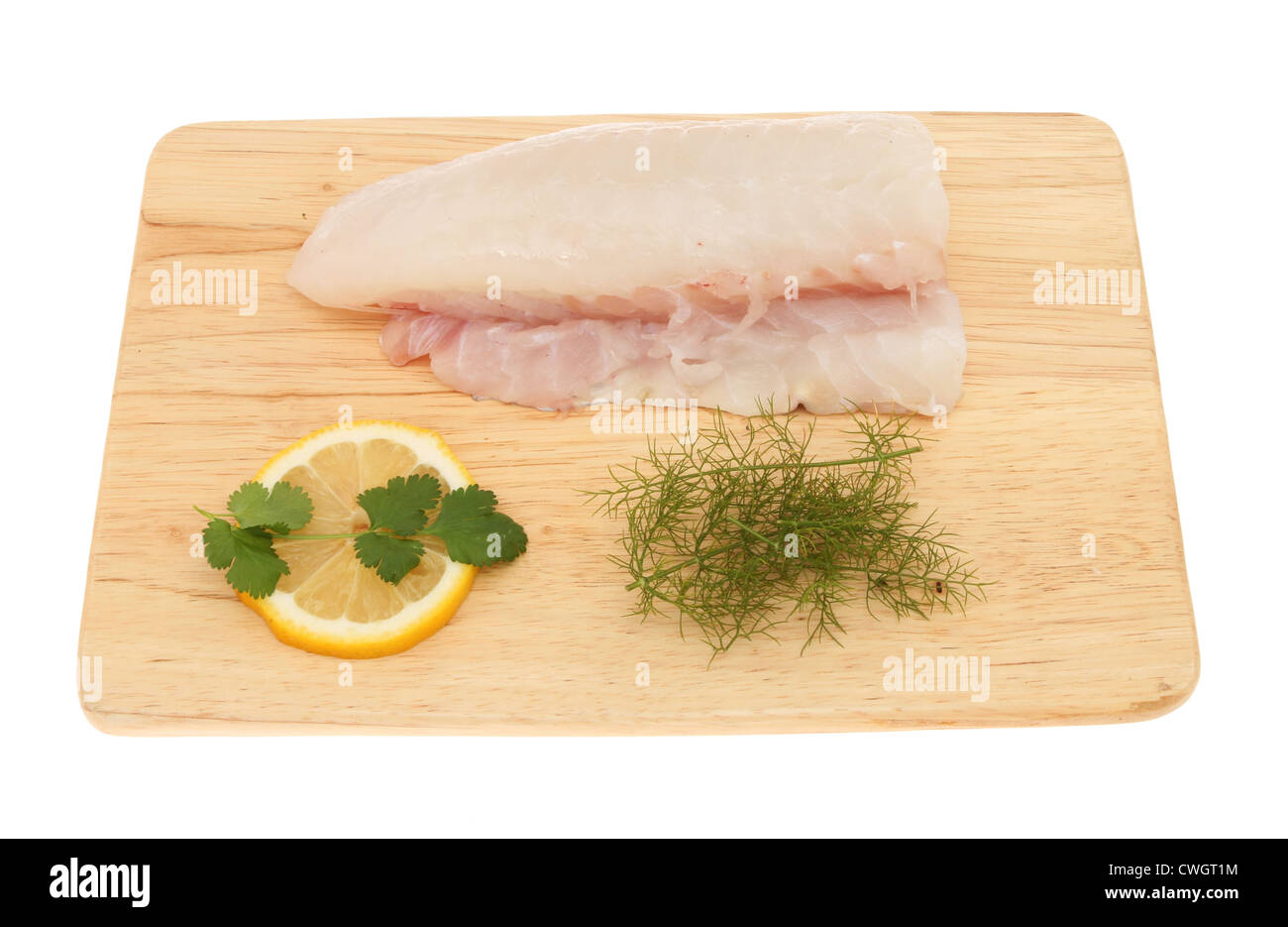 Fresh raw cod fillet on a board with lemon, parsley and fennel isolated ...