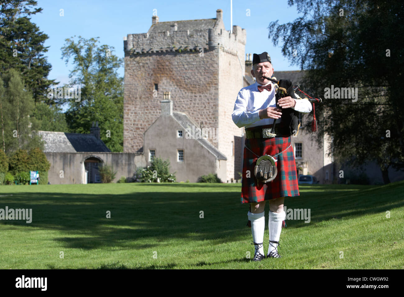 scottish bagpipe player playing pipes in front of kilravock castle ...