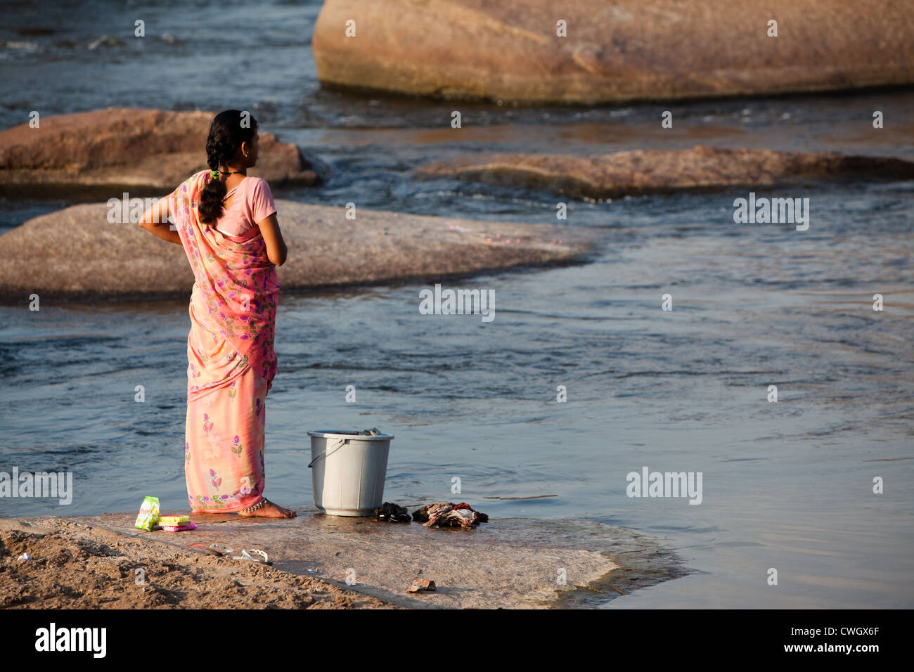 Woman in sari washing clothes in the Tungabhadra river in Hampi Stock ...