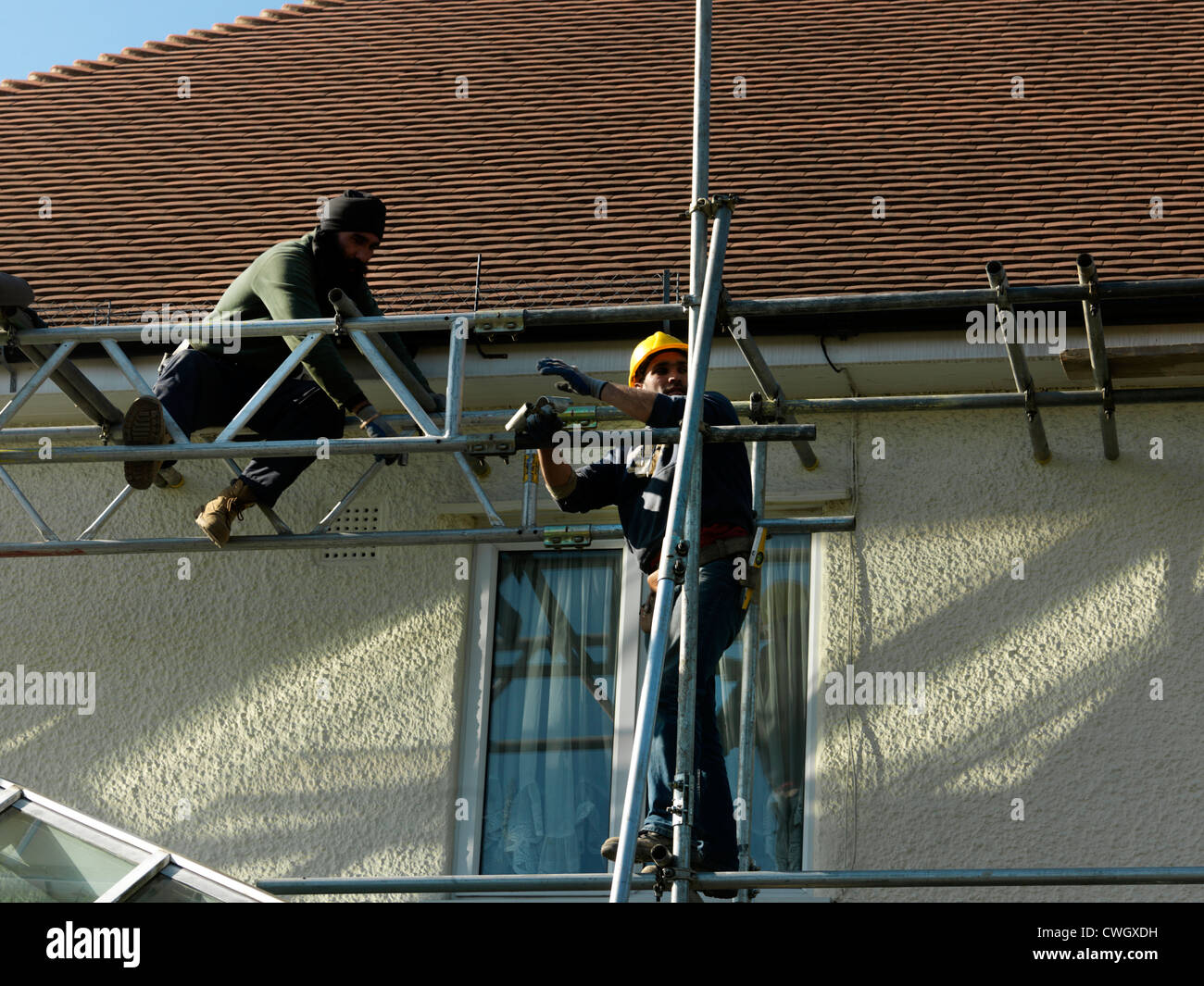Sikh Workmen Putting Up Scaffolding Around A House England Surrey Stock ...