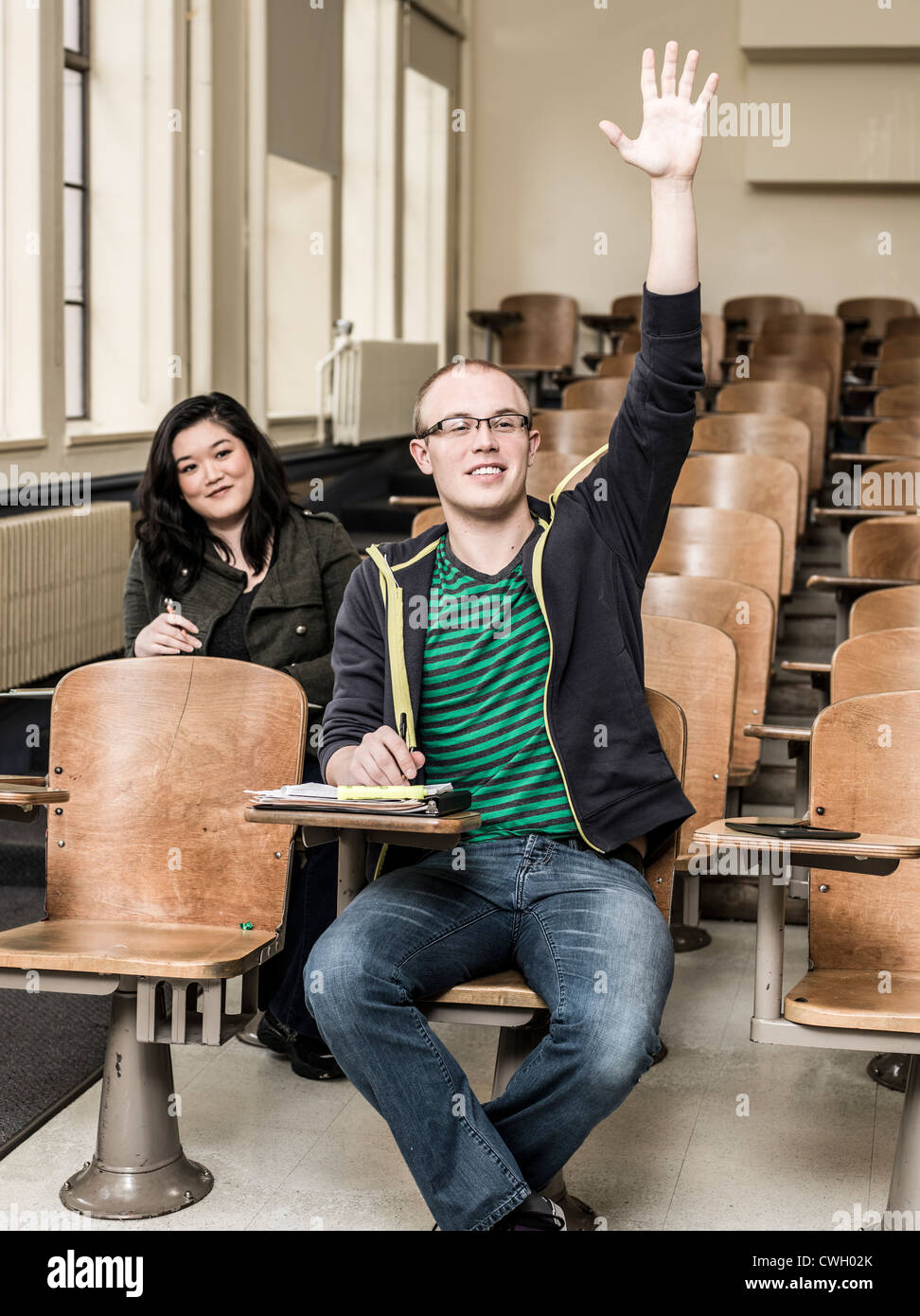Student raising his hand in classroom Stock Photo - Alamy
