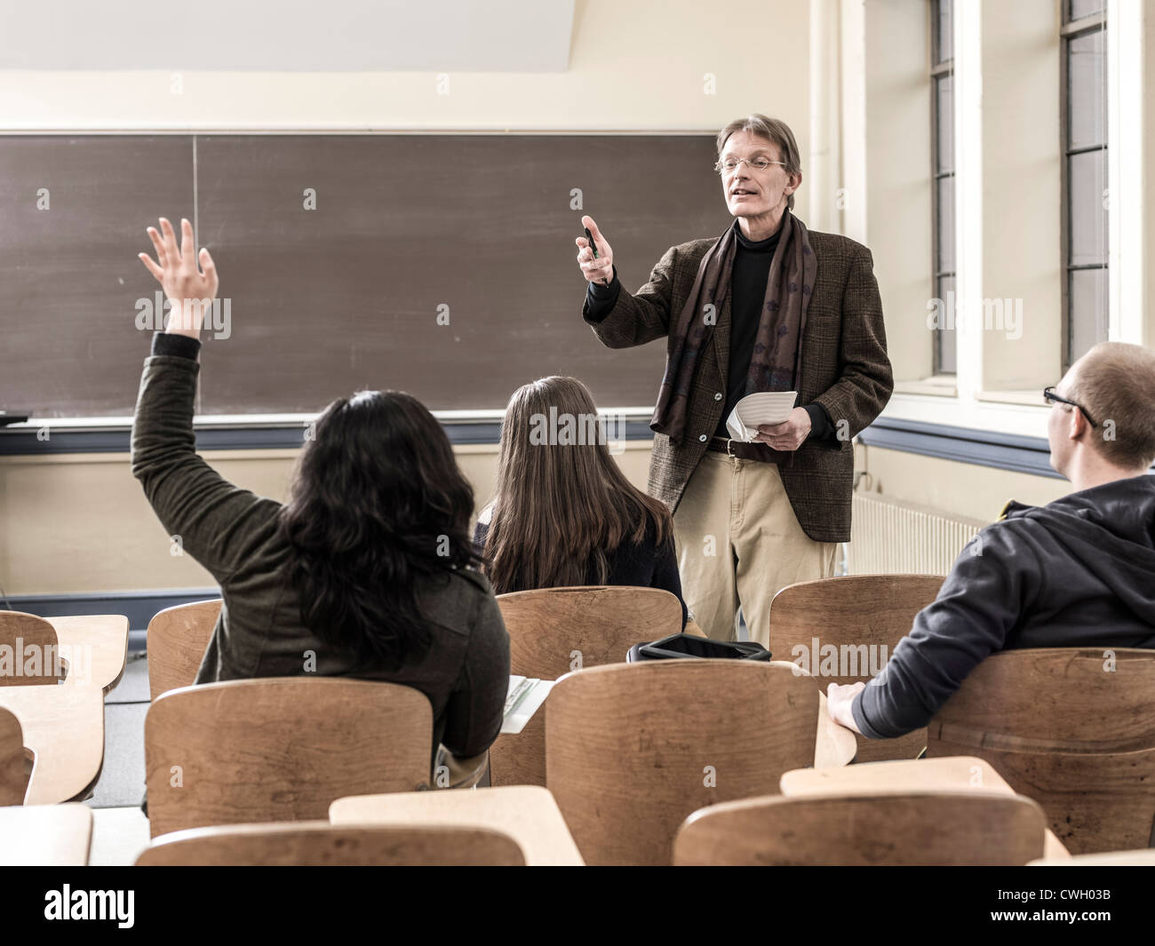 Teacher talking to students in classroom Stock Photo - Alamy