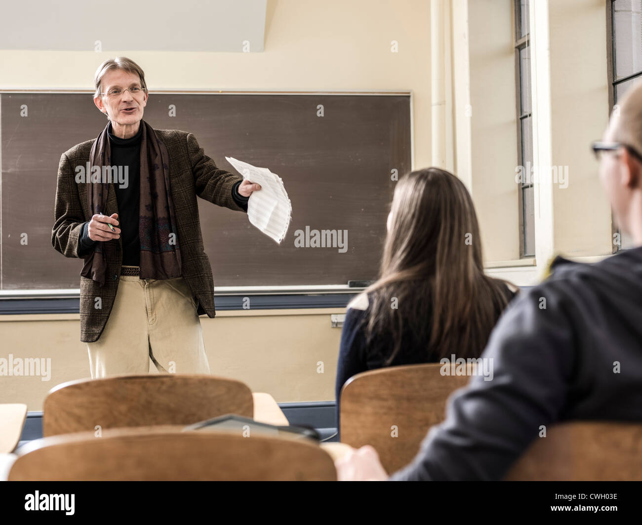 Teacher talking to students in classroom Stock Photo - Alamy