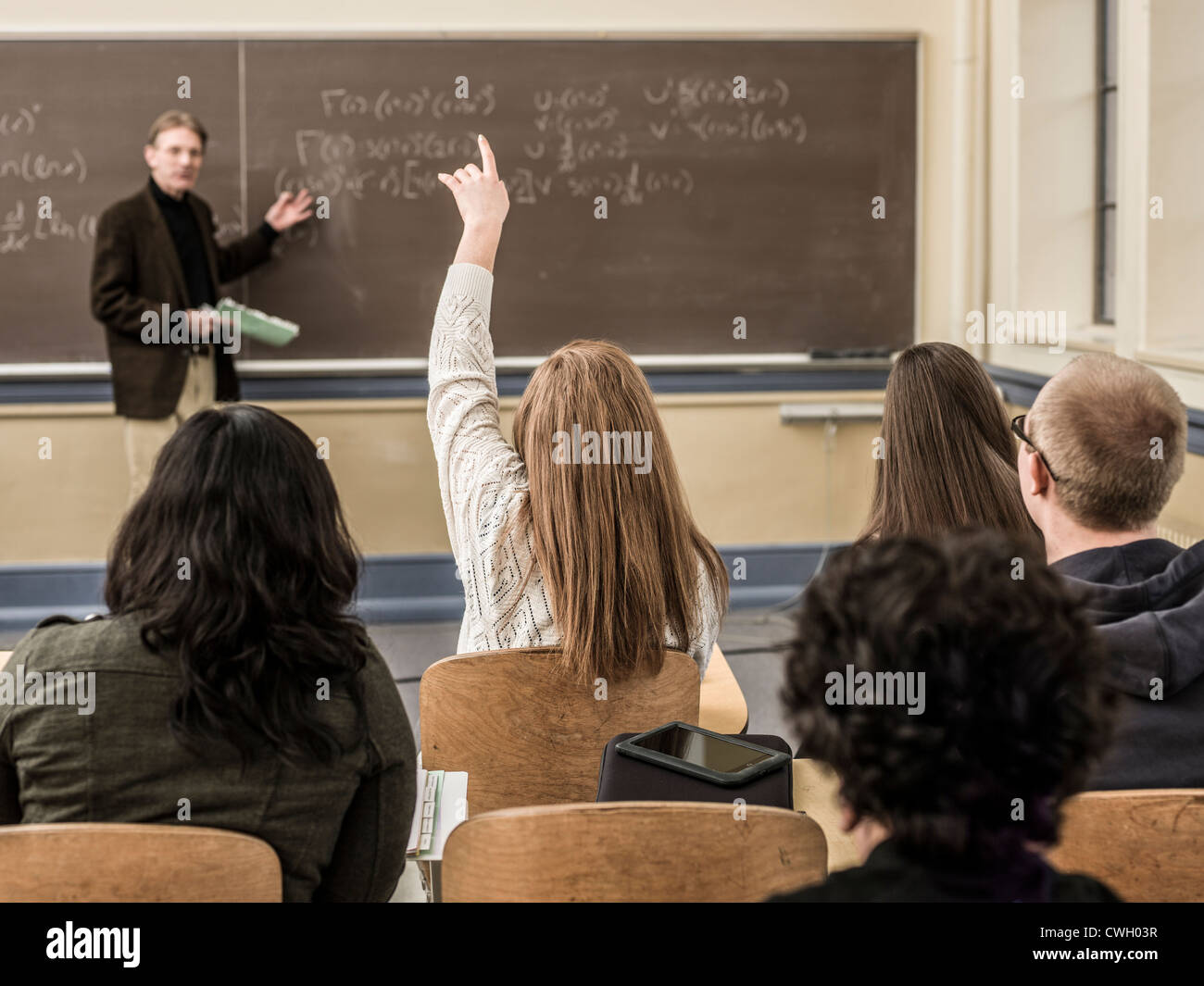 Teacher talking to students in classroom Stock Photo - Alamy