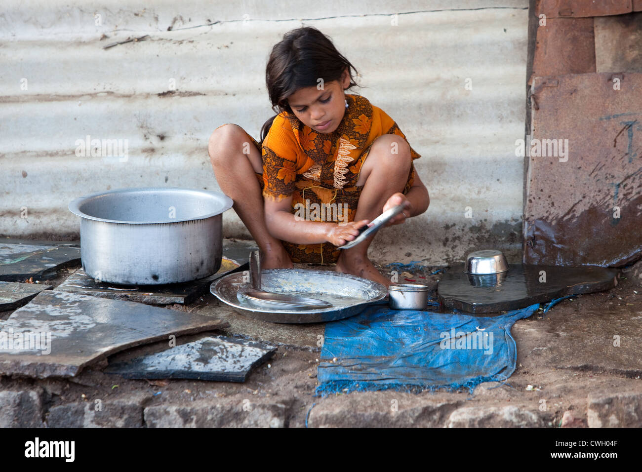 Young Indian girl washing pots outside her home in Hampi bazaar Stock ...