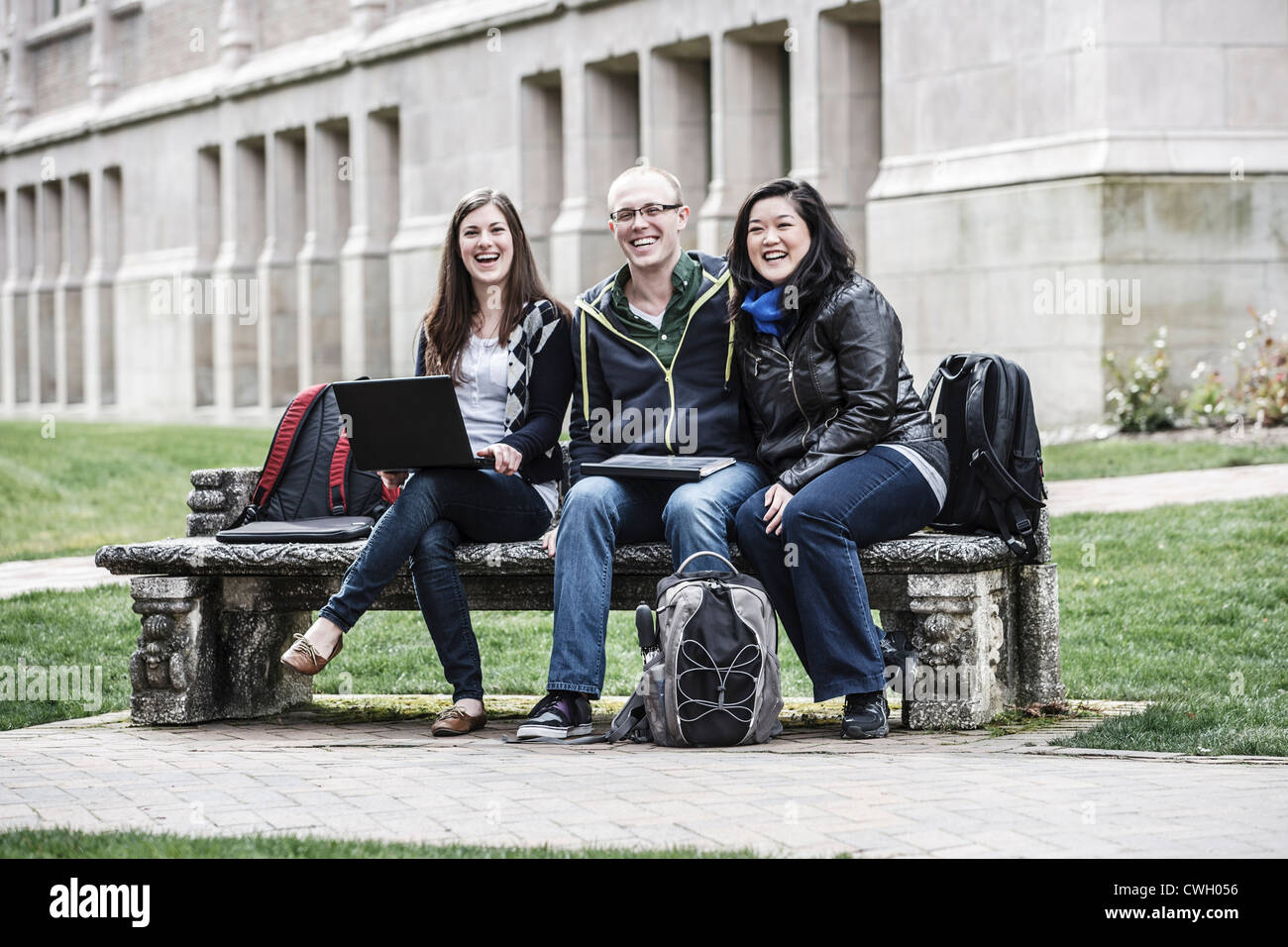Students sitting on bench together Stock Photo - Alamy