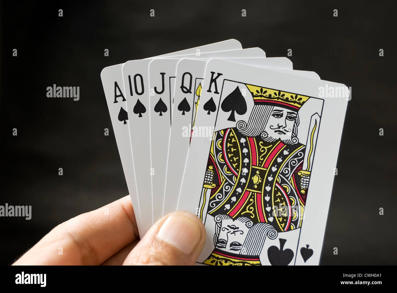 Royal Flush held by hand against black background Stock Photo - Alamy