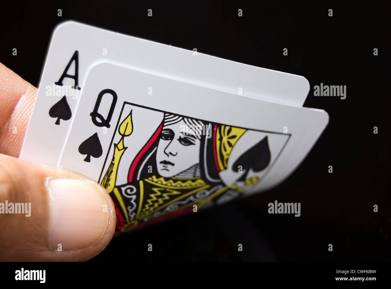 Blackjack cards held by hand against black background Stock Photo - Alamy