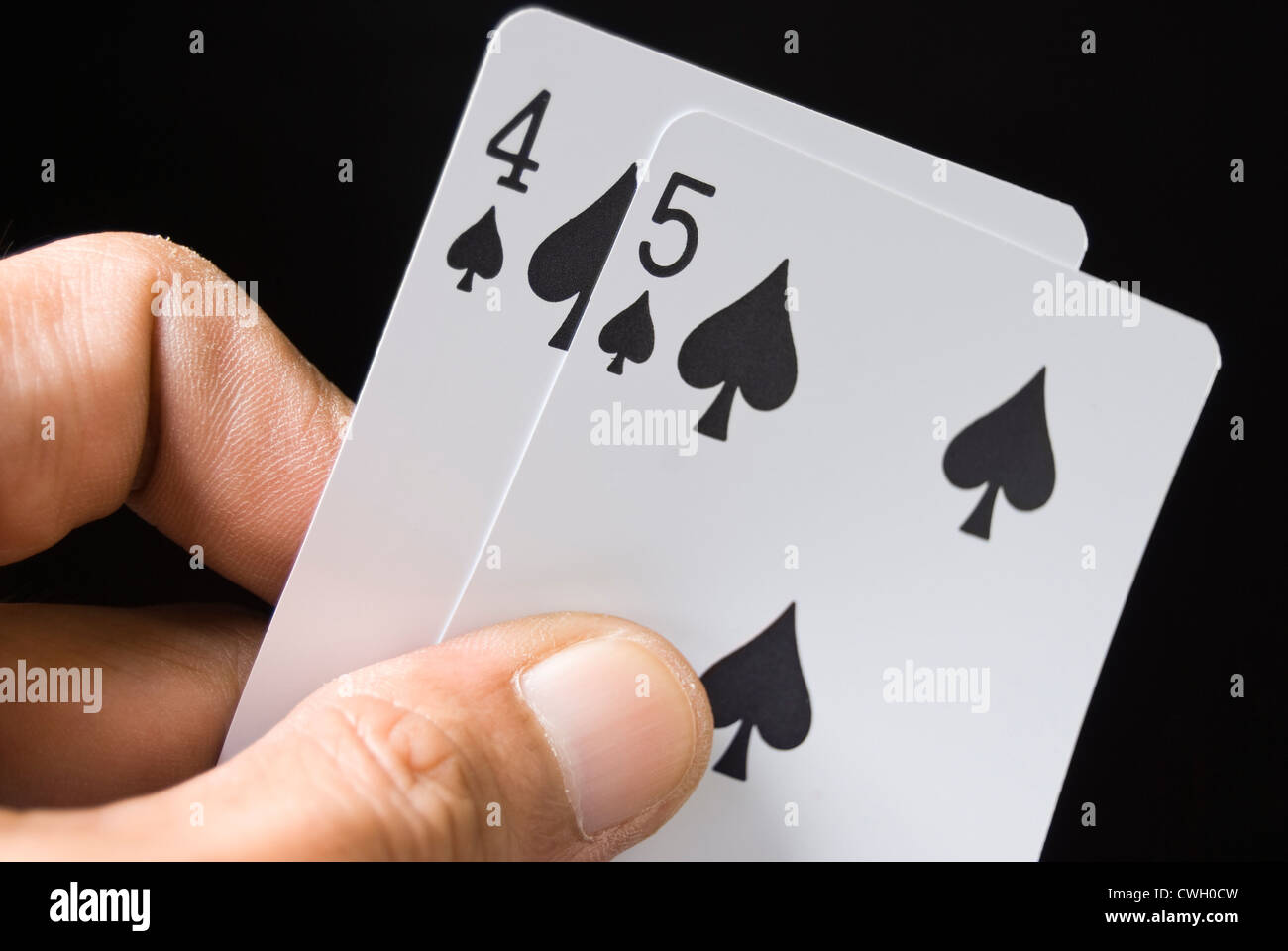 Lucky Nine cards held by hand against black background Stock Photo - Alamy
