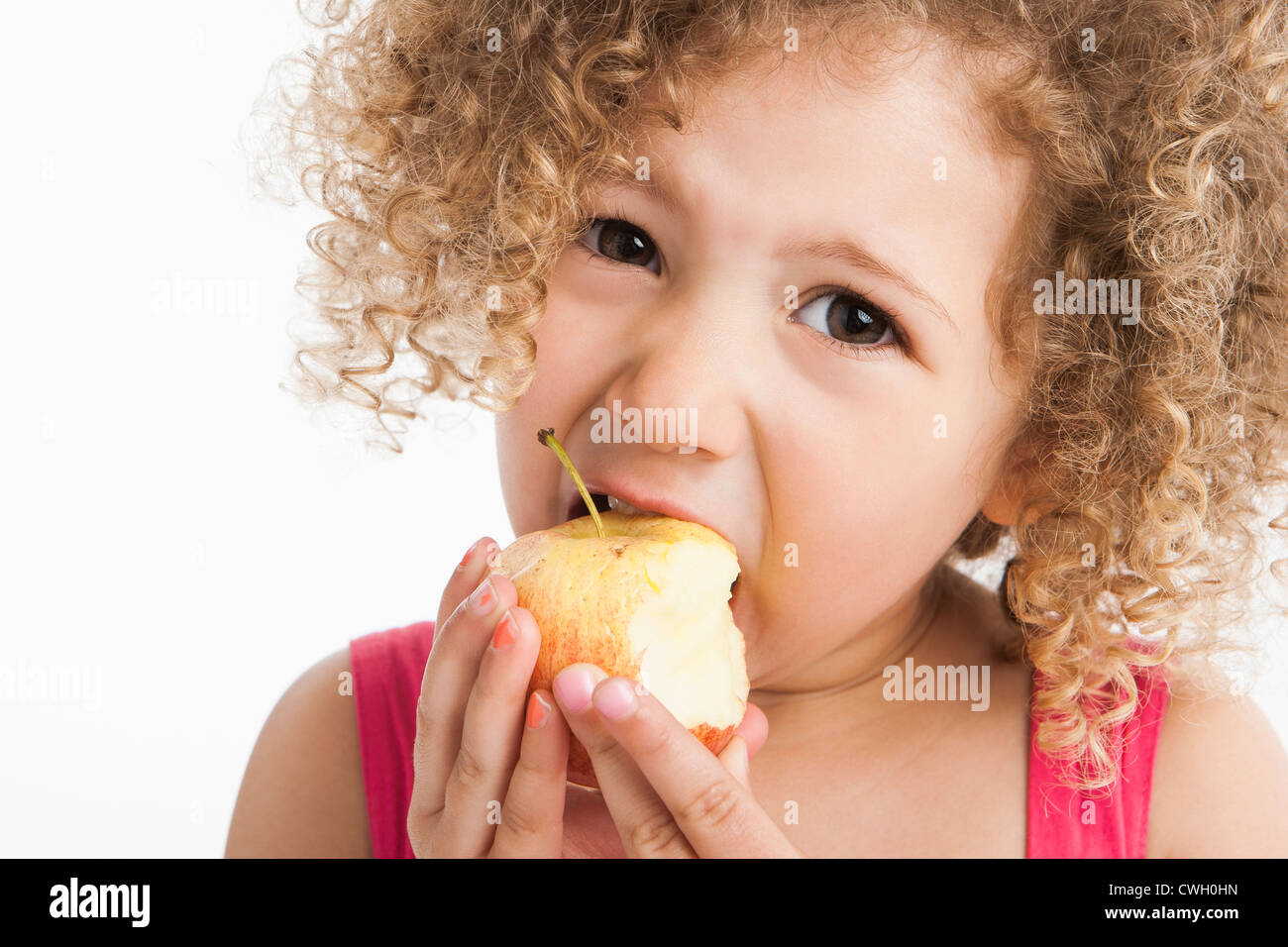 Mixed race girl eating apple Stock Photo - Alamy