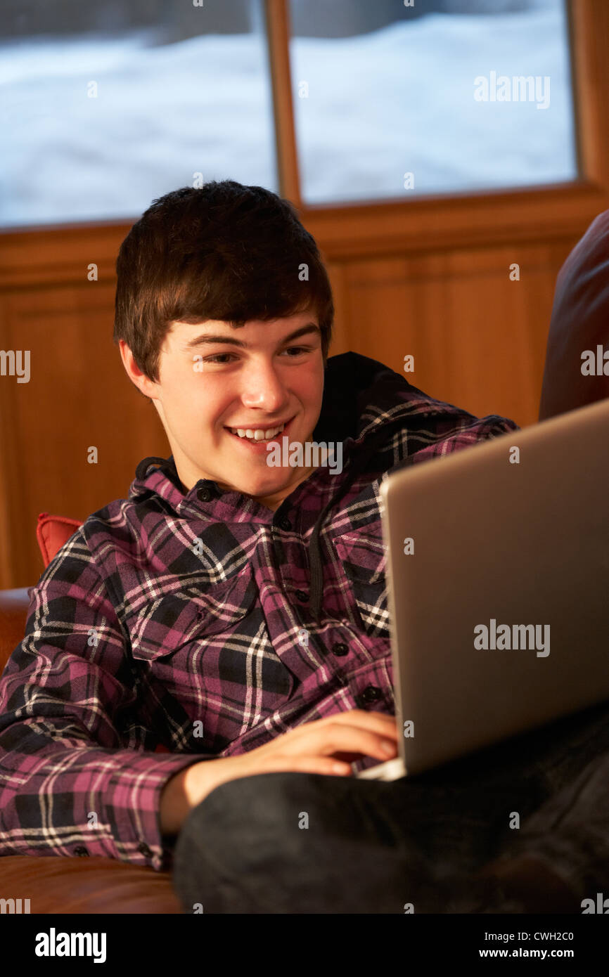 Teenage Boy Relaxing On Sofa With Laptop Stock Photo - Alamy