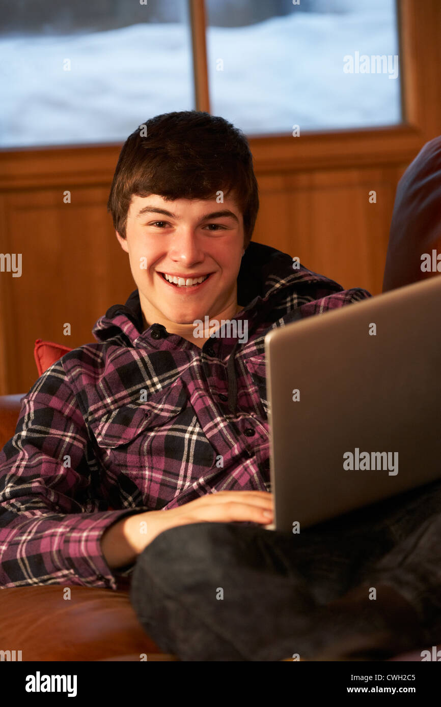 Teenage Boy Relaxing On Sofa With Laptop Stock Photo - Alamy