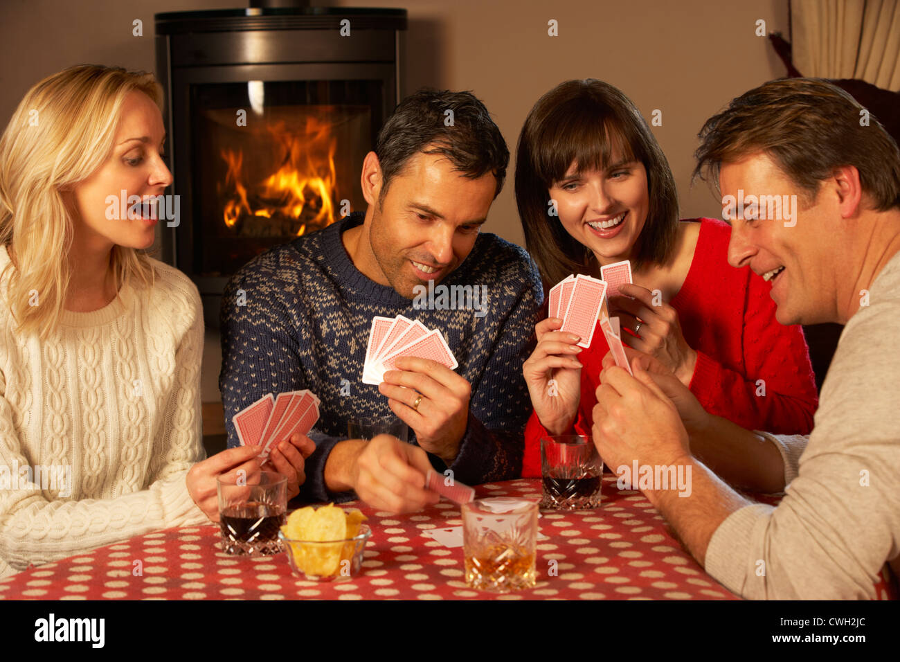 Group Of Middle Aged Couples Playing Cards Together Stock Photo - Alamy