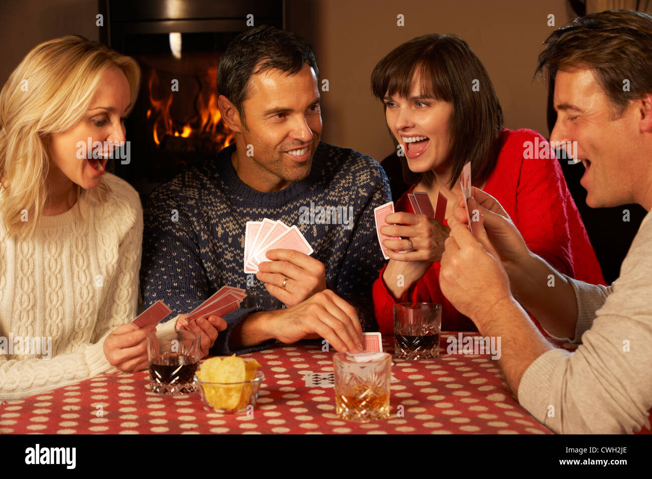 Group Of Middle Aged Couples Playing Cards Together Stock Photo - Alamy