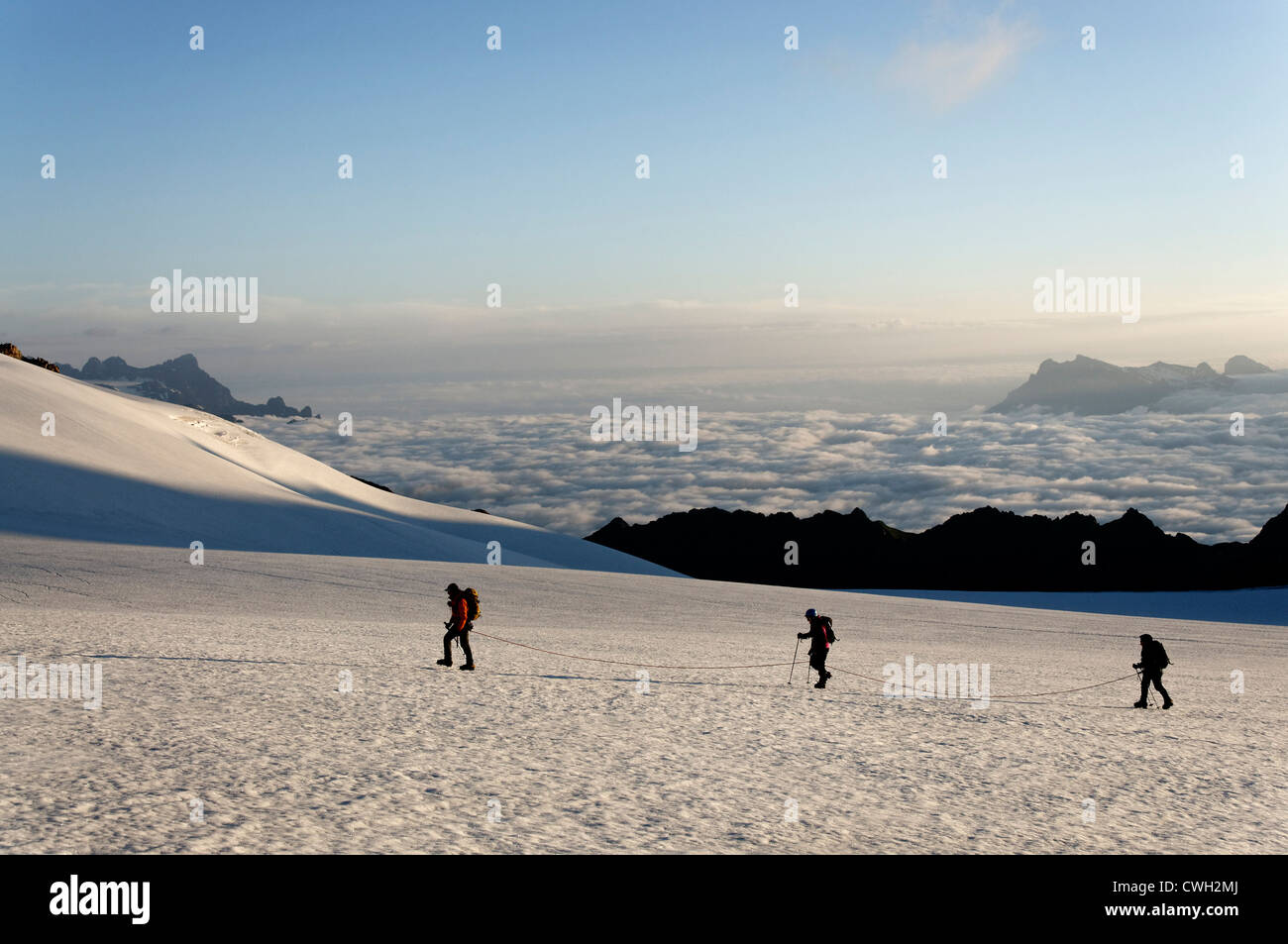 Climbers on a glacier above a sea of cloud hi-res stock photography and ...