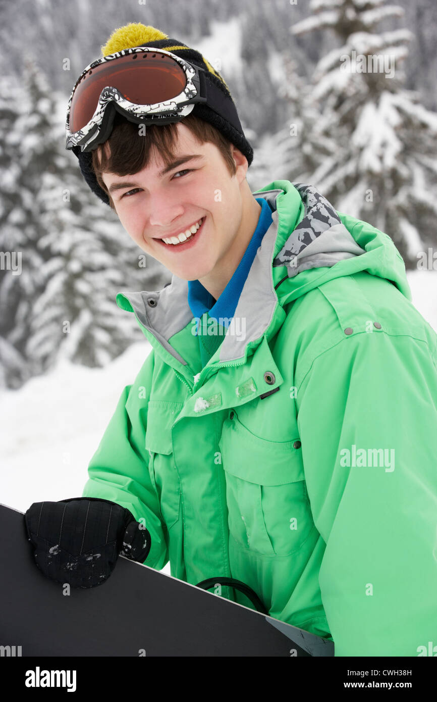 Teenage Boy With Snowboard On Ski Holiday In Mountains Stock Photo - Alamy