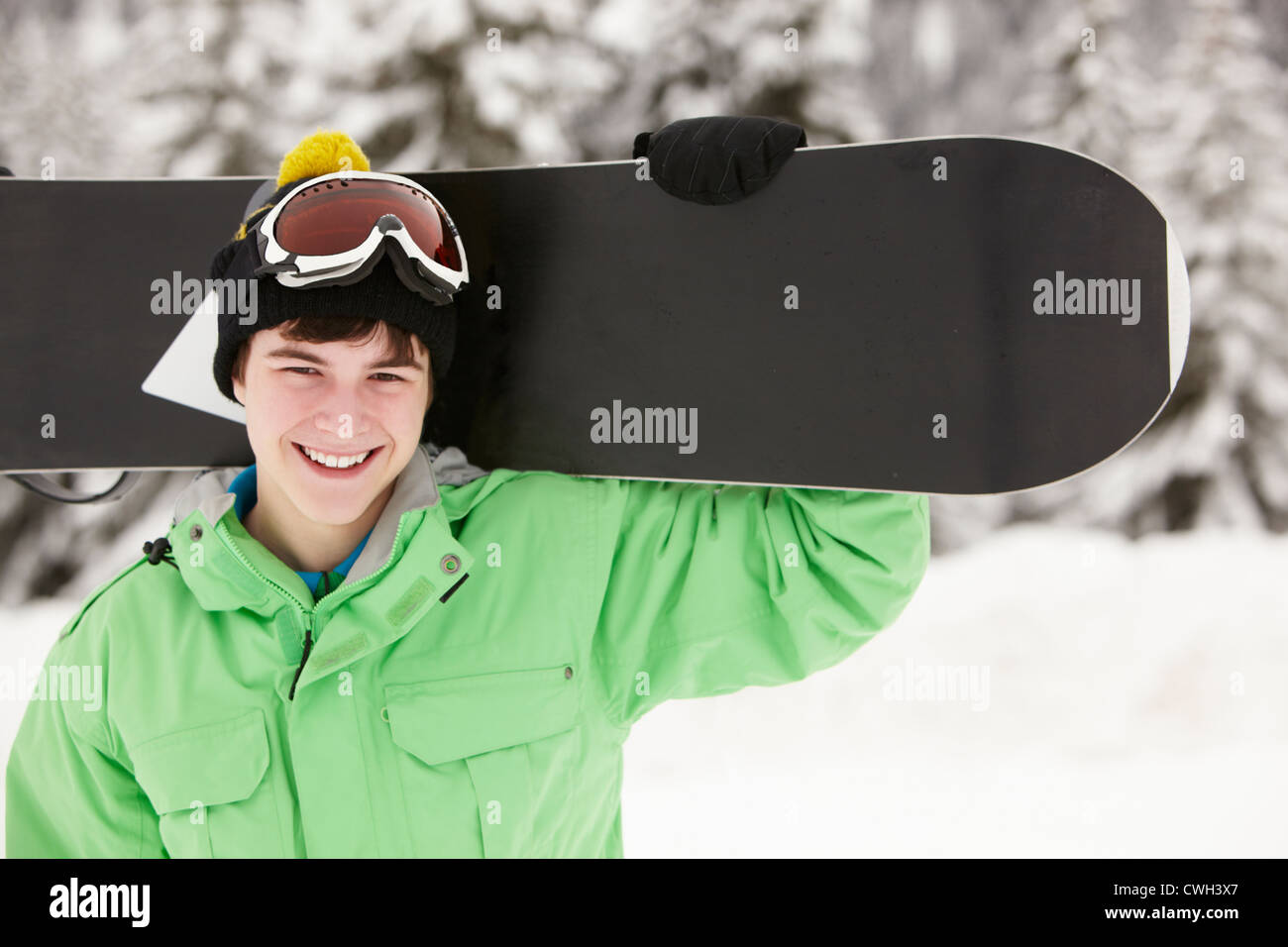 Teenage Boy With Snowboard On Ski Holiday In Mountains Stock Photo - Alamy