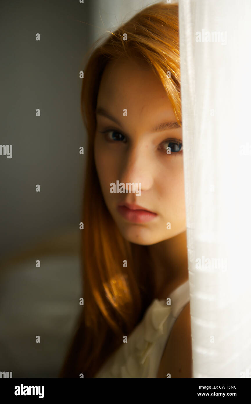 A teenage girl lit by window light in a white blouse Stock Photo - Alamy