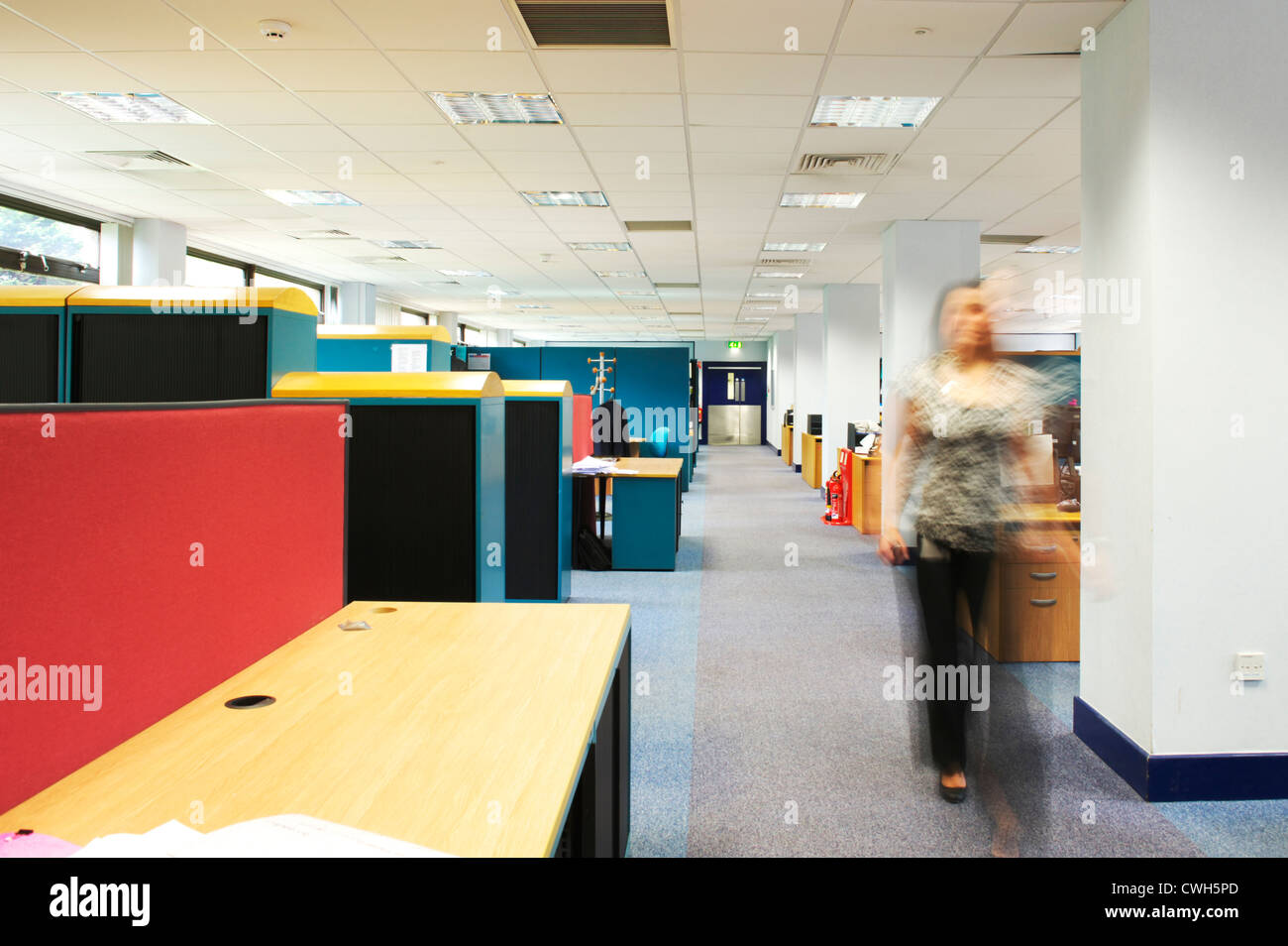 Office worker walks along the corridor in office, blurred by movement ...