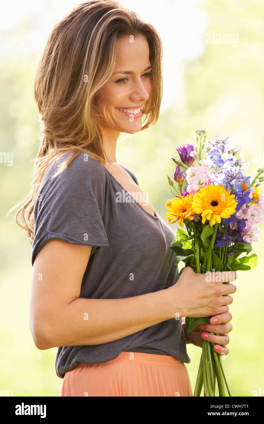 Woman Walking Through Summer Field Carrying Bouquet Of Flowers Stock ...