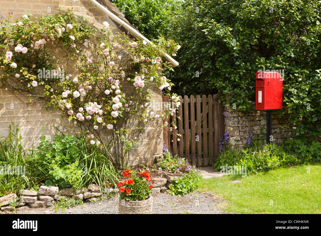 A traditional red British post box in the Cotswold village of Taynton ...