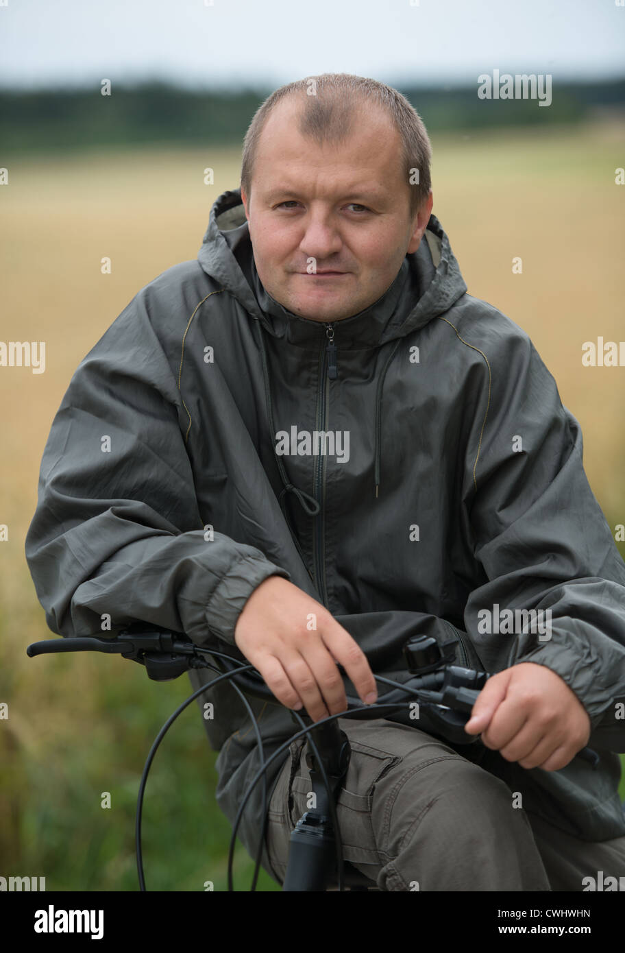 young bald man sitting on bicycle Stock Photo - Alamy