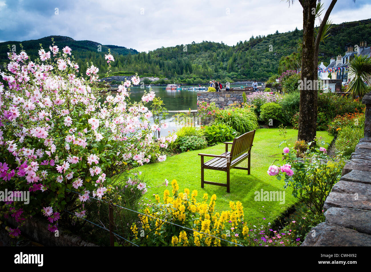 Small ornamental private flower garden with lawn on bank of Loch Carron ...