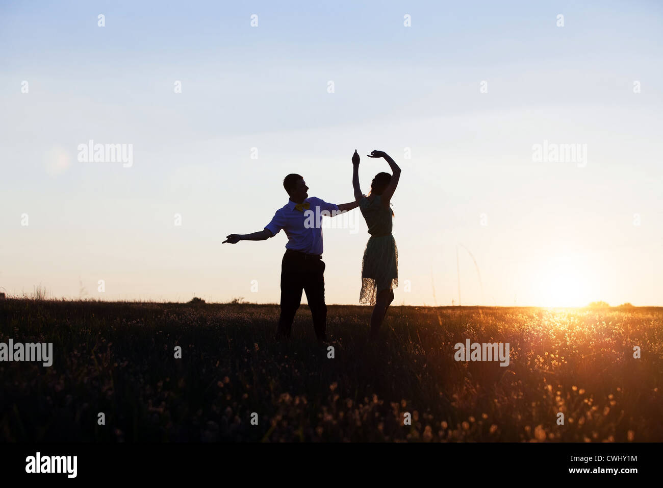 Young couple silhouettes dancing on the field at sunset Stock Photo - Alamy