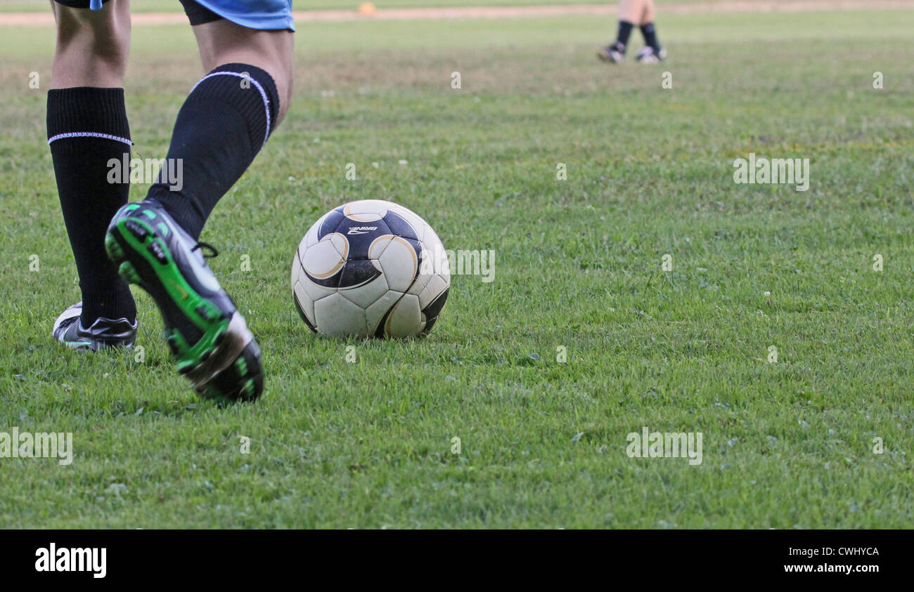 A soccer player kicks a ball Stock Photo - Alamy