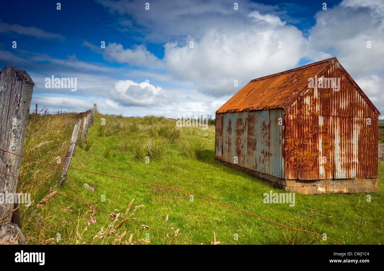 A rundown, rusty barn in a field on the Isle of Skye in Scotland, UK ...