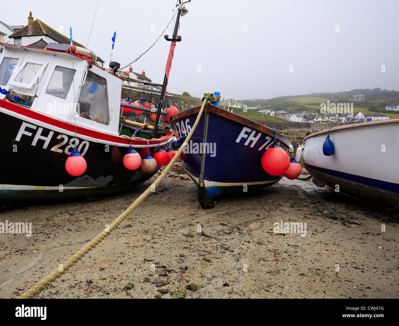 Fishing boats in misty Cornwall village Stock Photo - Alamy