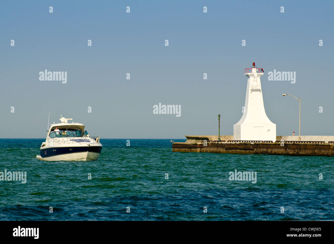 Boat passing a lighthouse Stock Photo - Alamy