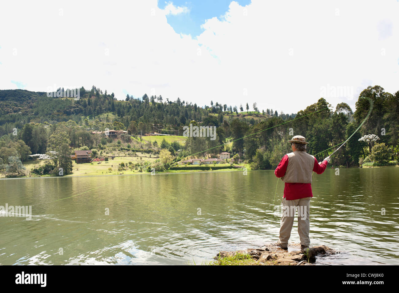 Hispanic man fishing in lake Stock Photo - Alamy