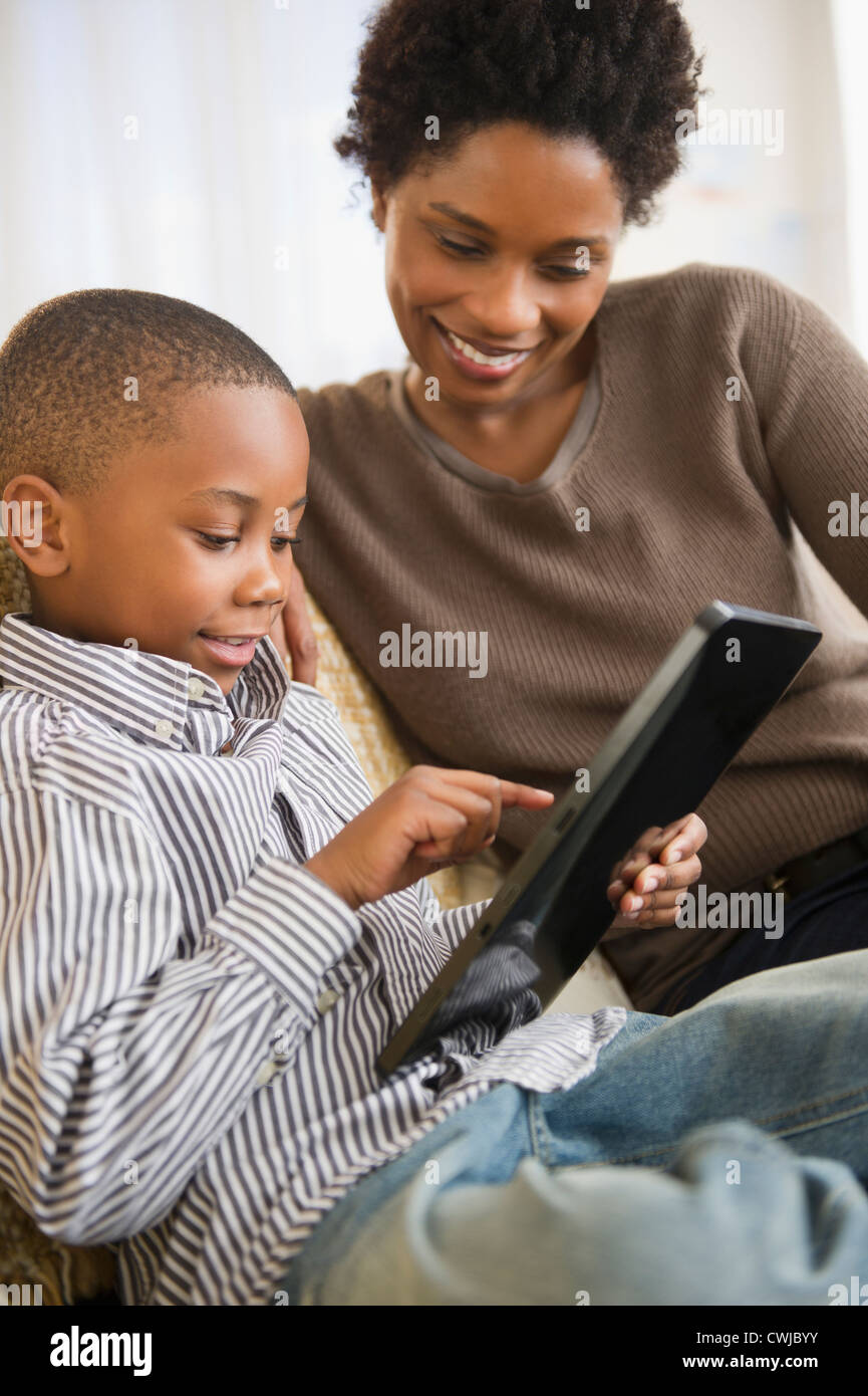 Black mother and son using digital tablet Stock Photo - Alamy