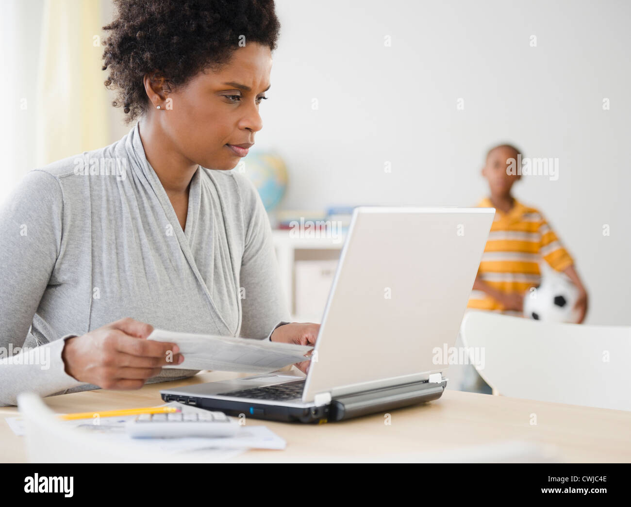 Black woman paying bills online with laptop Stock Photo - Alamy