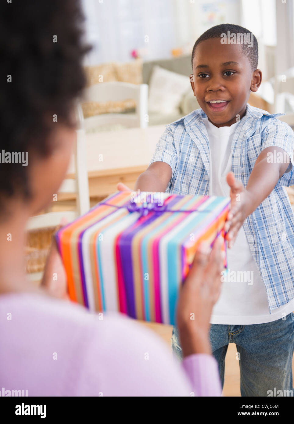 Black son handing mother a gift Stock Photo - Alamy