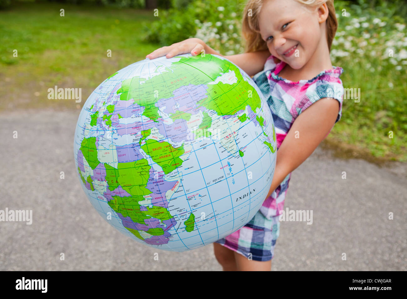 Little girl holding a colorful earth globe outdoors Stock Photo - Alamy
