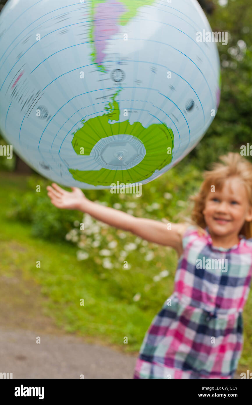 Little girl throwing an earth globe high in the air. Motion blur Stock ...