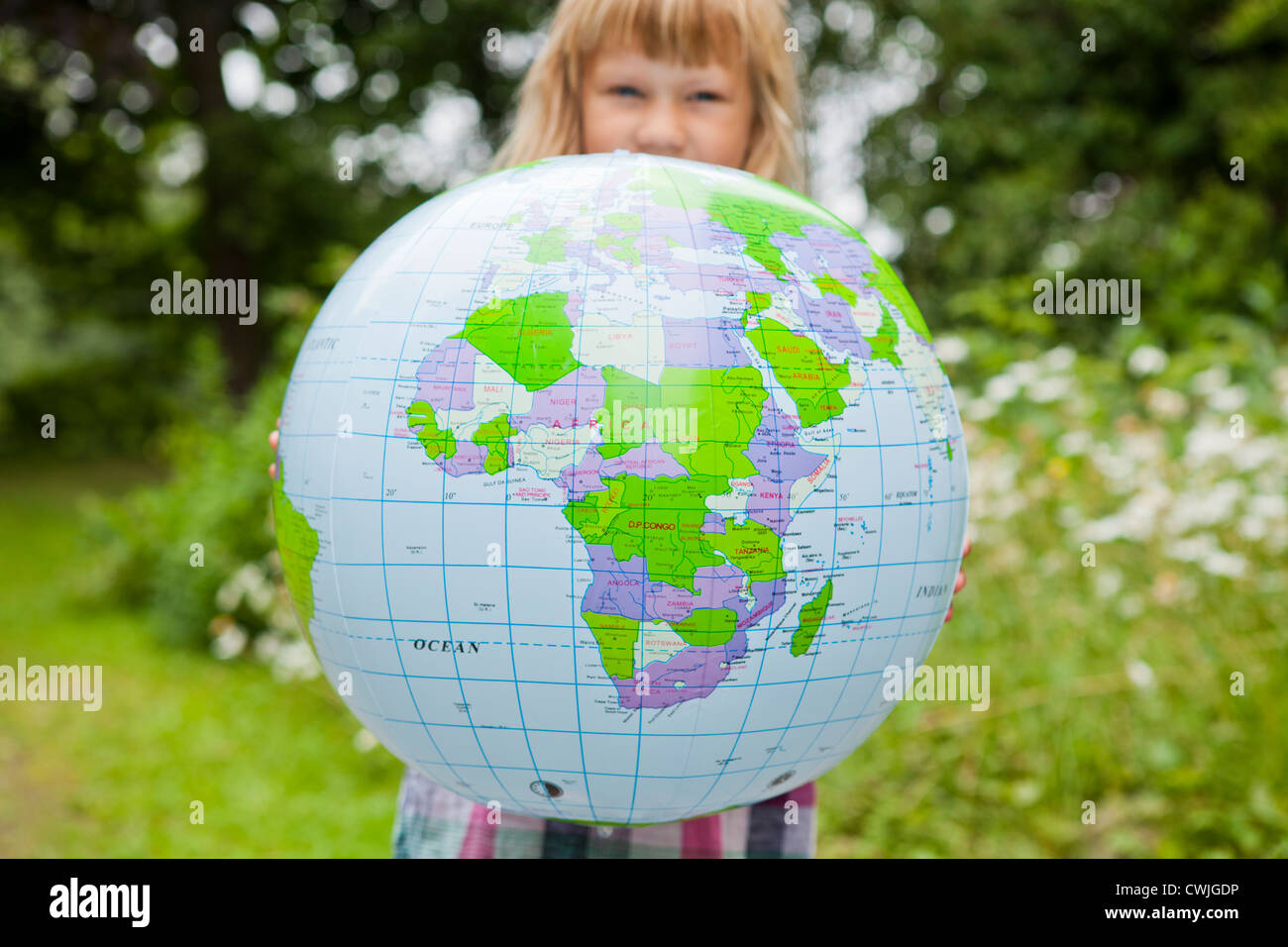 Little girl holding a colorful earth globe outdoors Stock Photo - Alamy