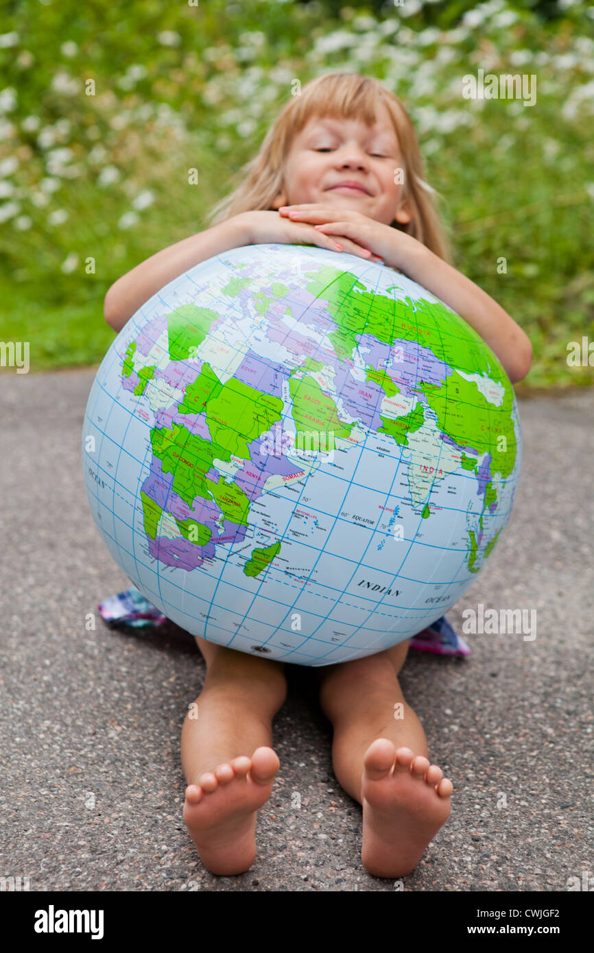 Little girl holding a colorful earth globe outdoors Stock Photo - Alamy