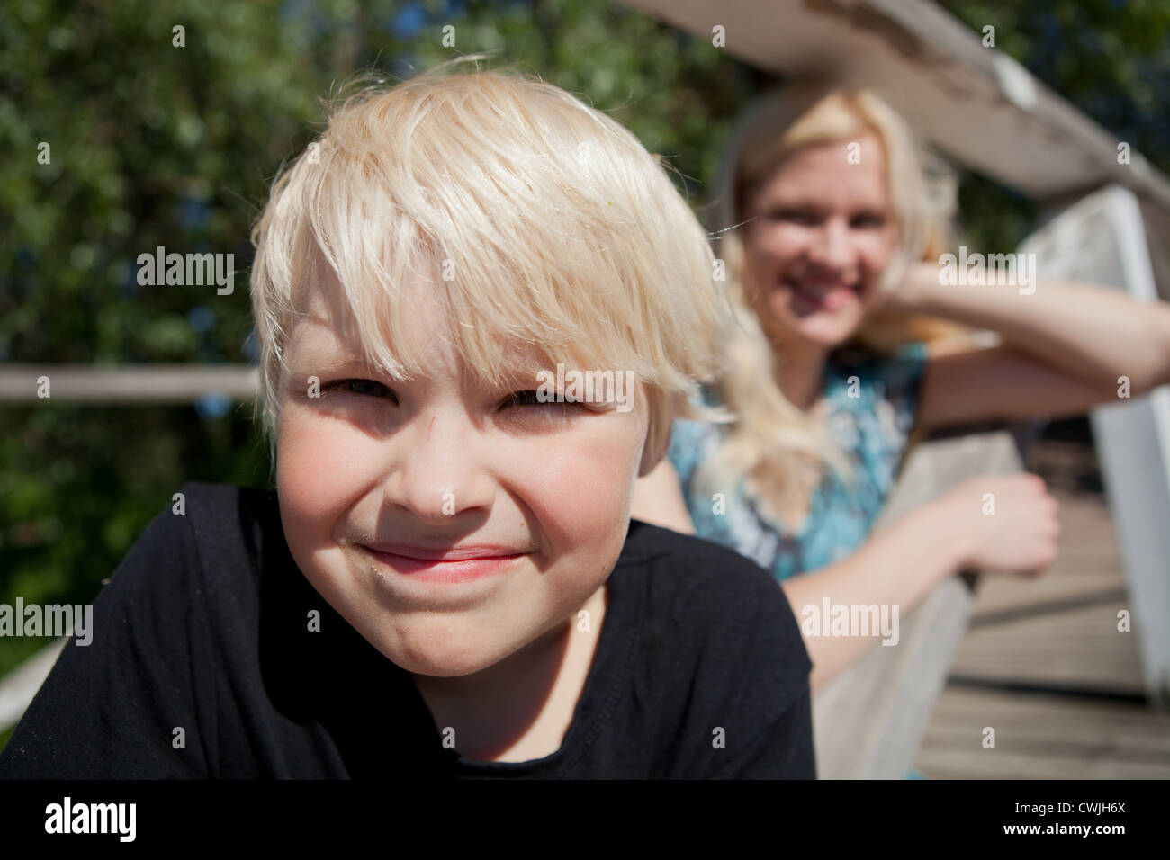 Portrait of a boy outdoors with his mother in the background Stock ...