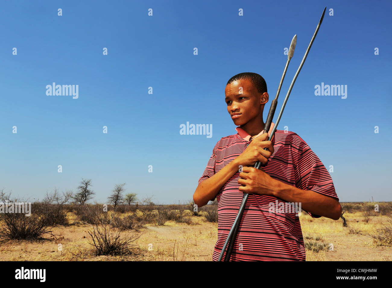 Boy of the indigenous San tribe with spears, Namibia, Kalahari desert ...