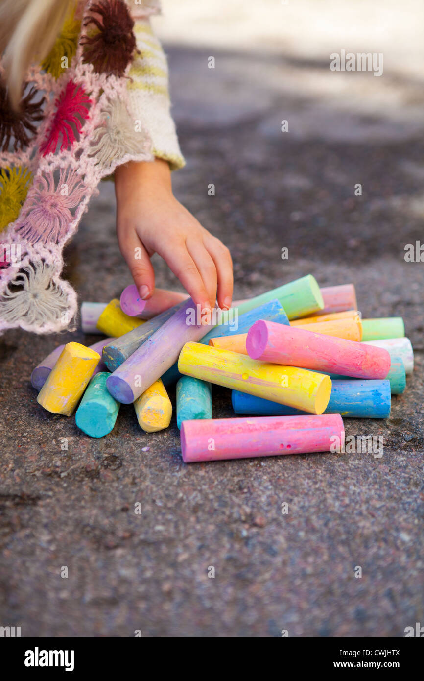 Cute little girl drawing with chalk outdoors Stock Photo - Alamy