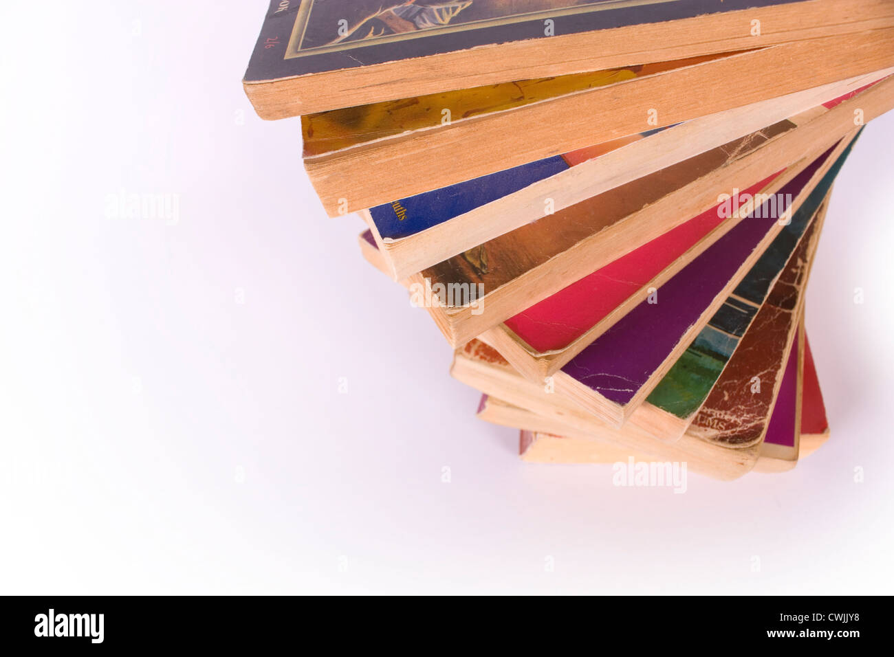 Stack of colorful old paperback books in spiral stack on white ...
