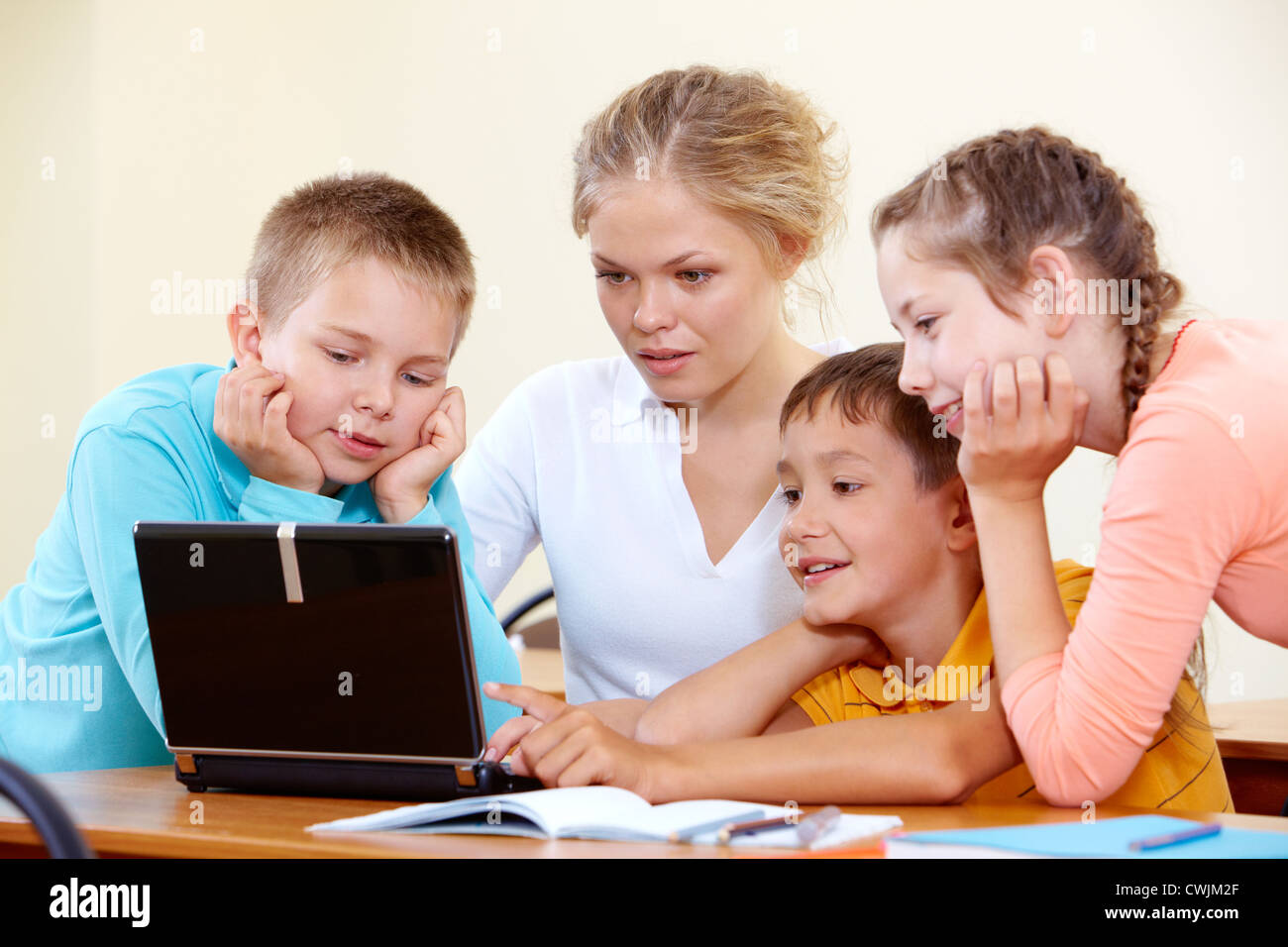 Smart schoolchildren and teacher working with laptop Stock Photo - Alamy